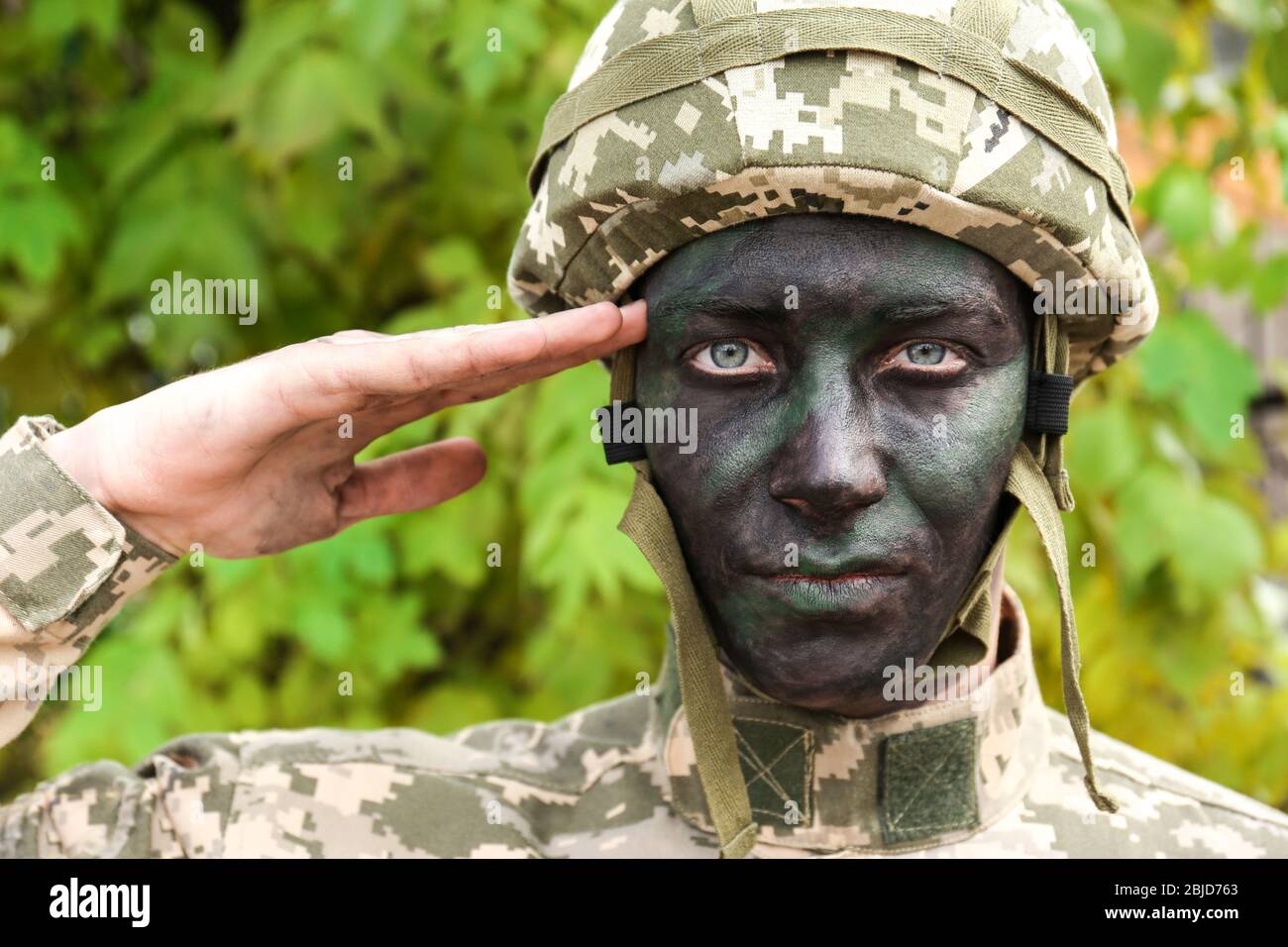 Close up view of saluting soldier on blurred green background Stock ...