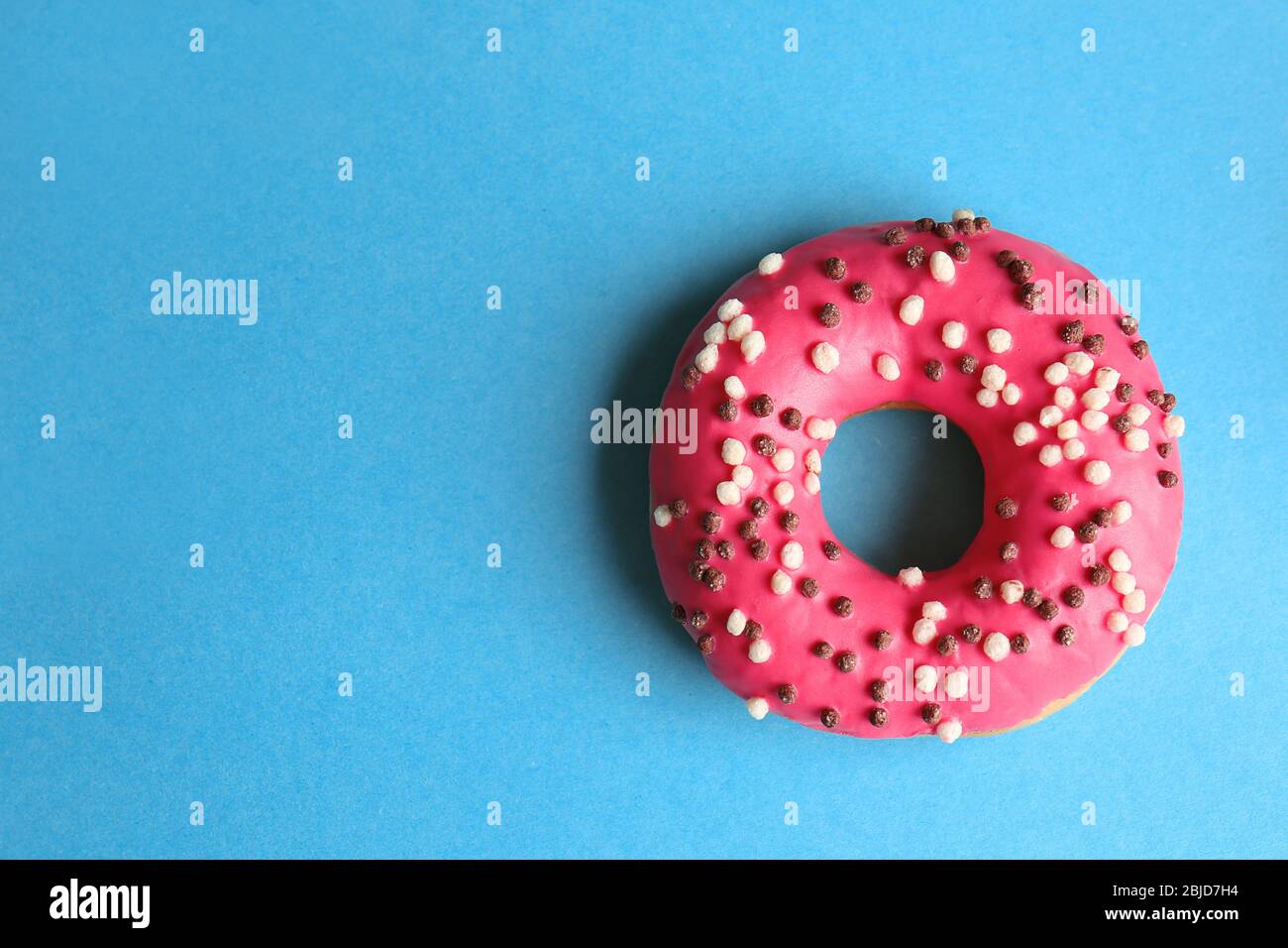 Glazed donut on color background Stock Photo - Alamy