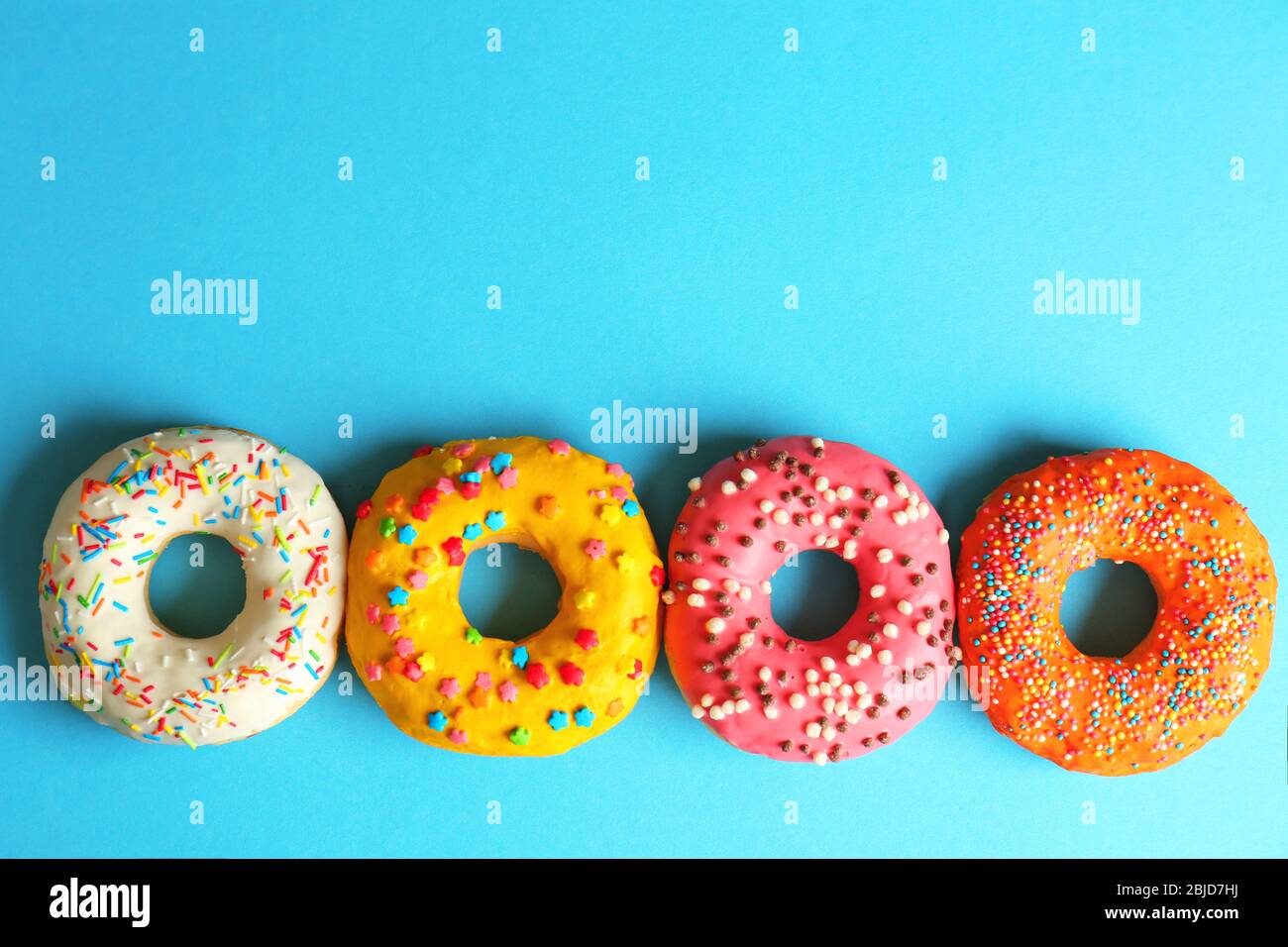 Glazed donuts on color background Stock Photo - Alamy