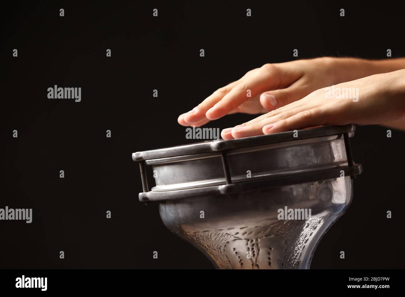 Hands of man playing African drum on dark background Stock Photo - Alamy