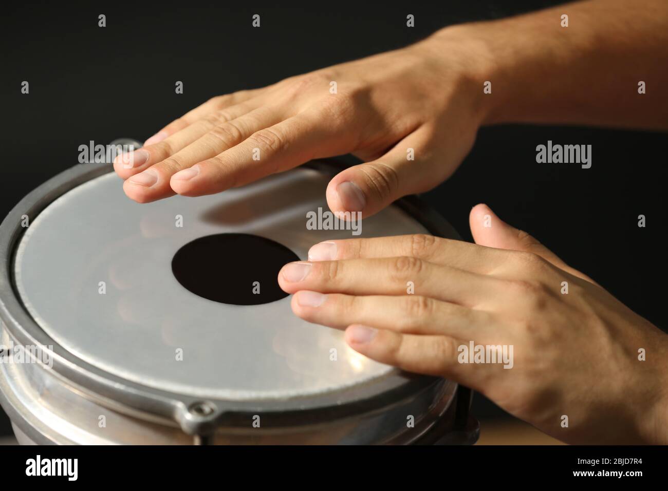 Hands of man playing African drum on dark background, close up Stock ...