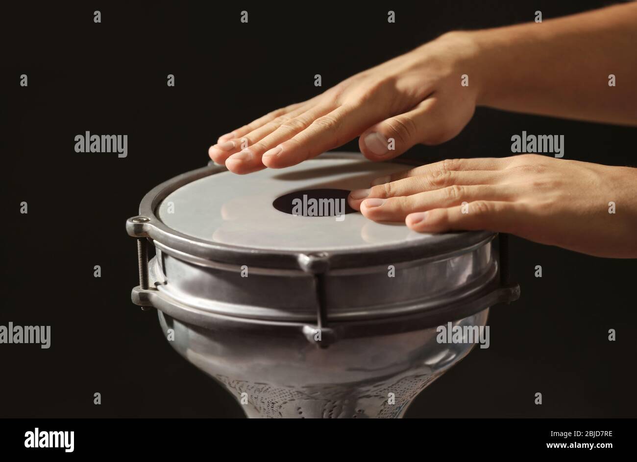 Hands of man playing African drum on dark background Stock Photo - Alamy