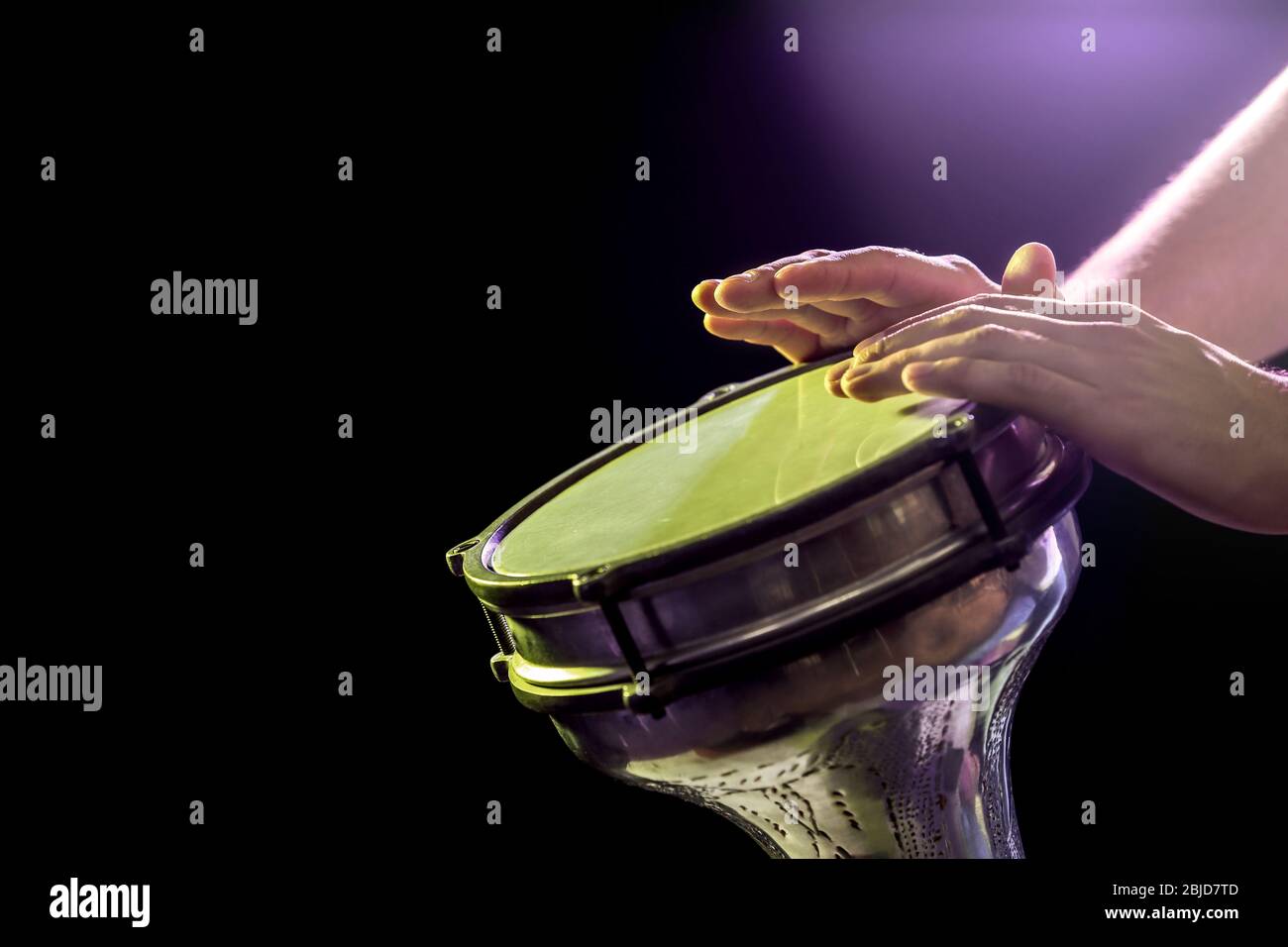 Hands of man playing African drum on dark background Stock Photo - Alamy