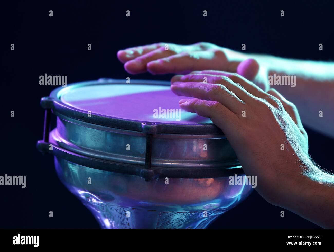 Hands of man playing African drum on dark background Stock Photo - Alamy
