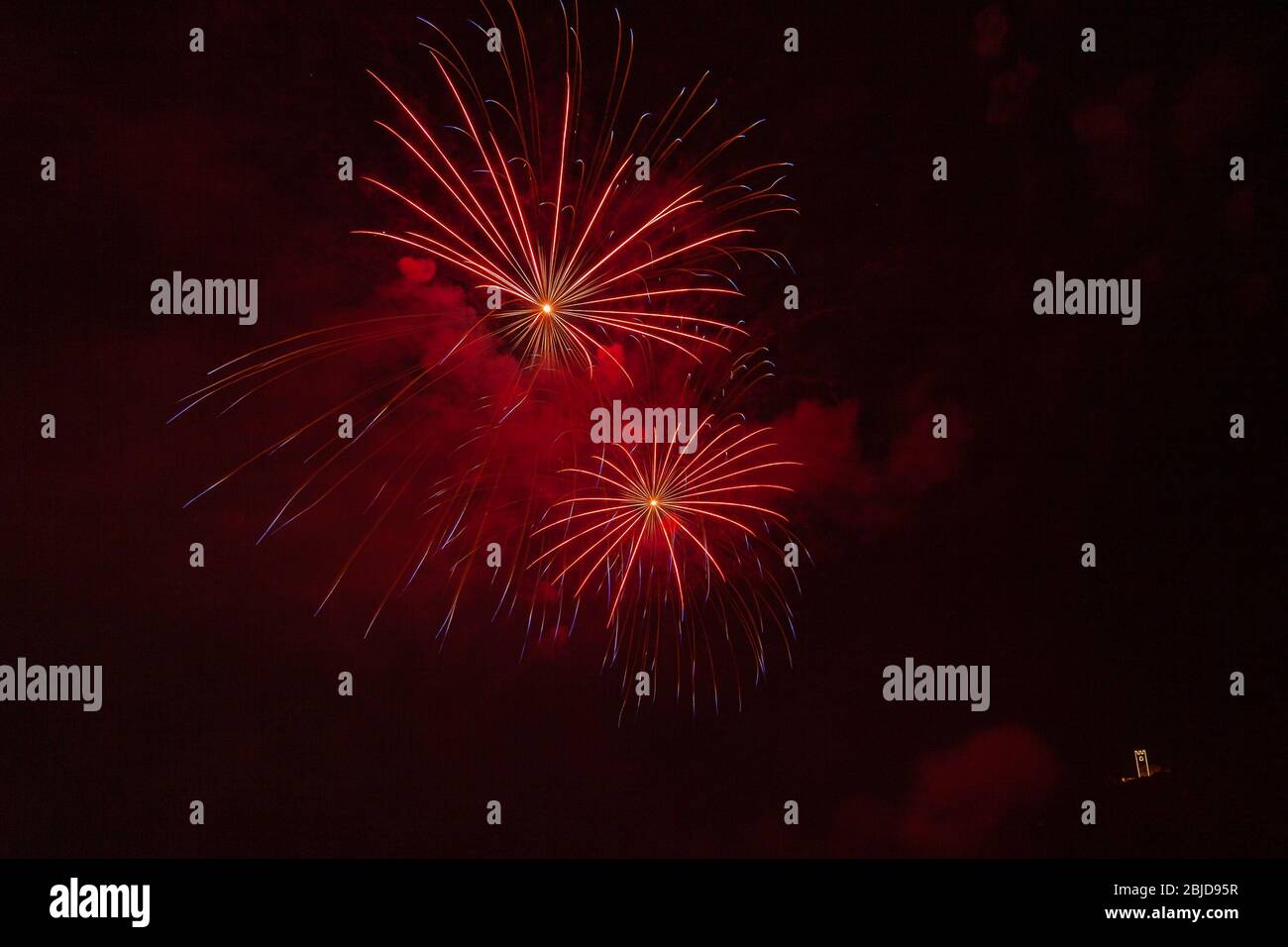Red fireworks over an illuminated church Stock Photo - Alamy