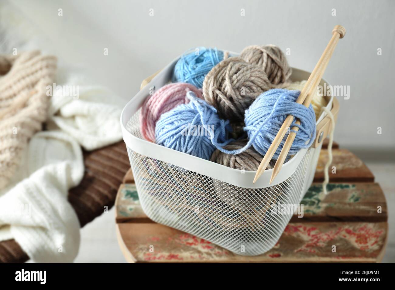 Plastic box with knitting yarn and needles on stool Stock Photo - Alamy