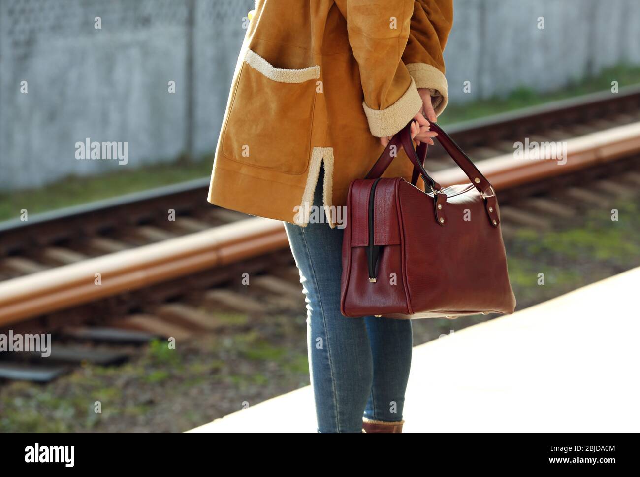 Woman at the railway station with bag Stock Photo - Alamy