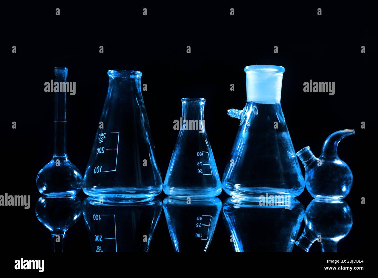 Test beakers and flasks on dark background Stock Photo - Alamy