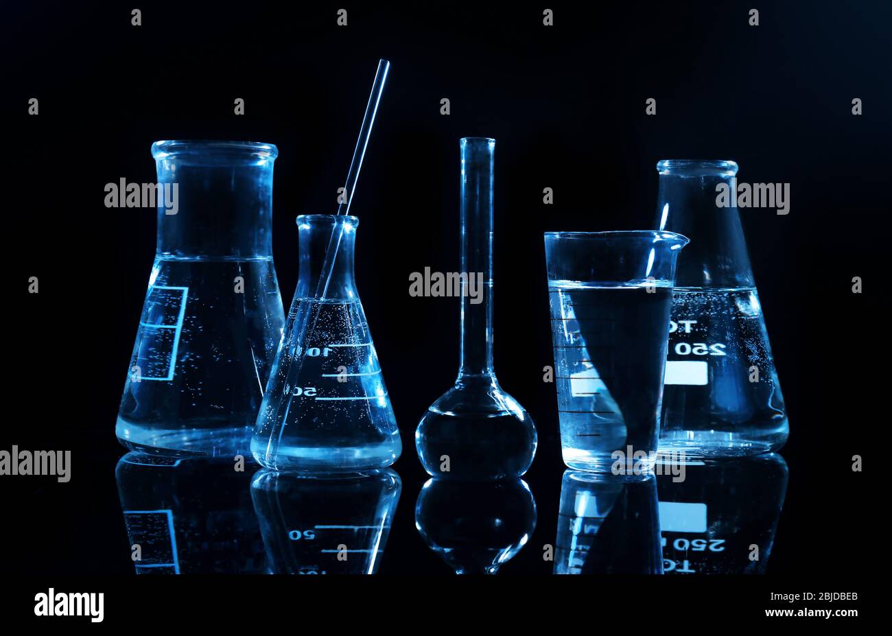 Test beakers and flasks on dark background Stock Photo - Alamy
