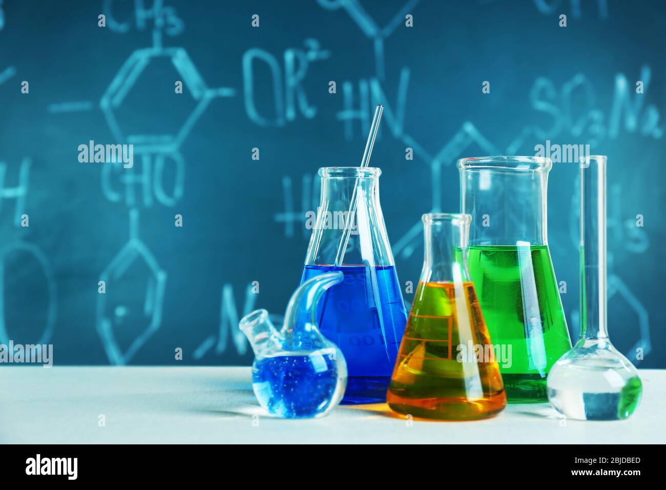 Test beakers and flasks on blackboard background Stock Photo - Alamy