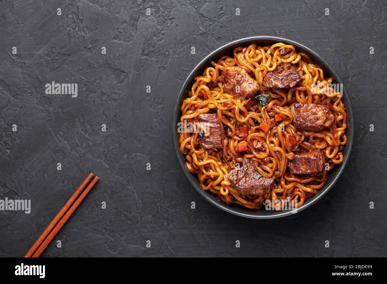 Ram-Don or Chapaguri noodles with beef steak in black bowl on dark ...