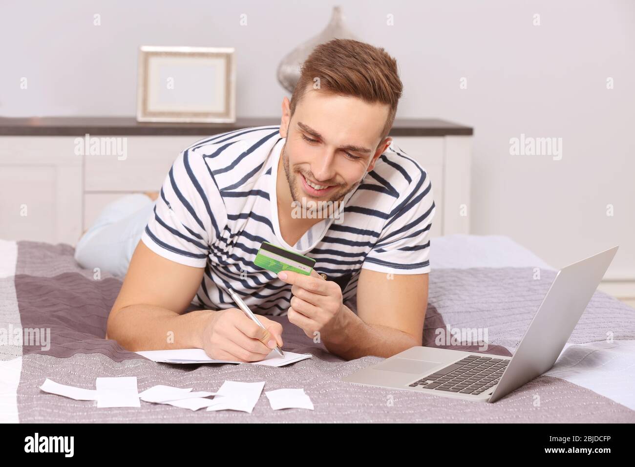 Handsome young man calculating taxes at home Stock Photo - Alamy