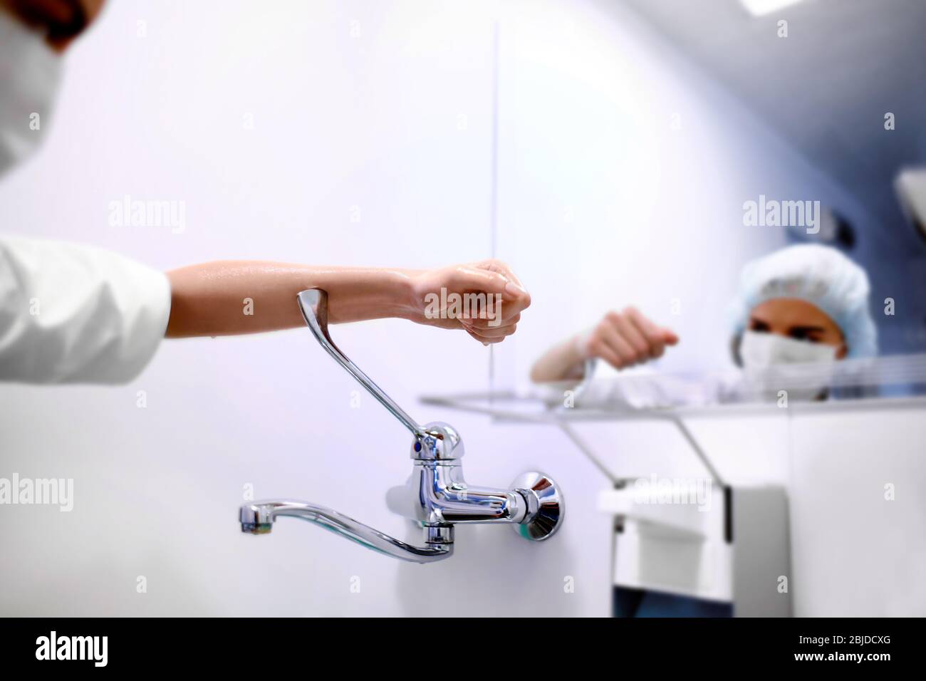 Surgeon washing hands at sink Stock Photo - Alamy