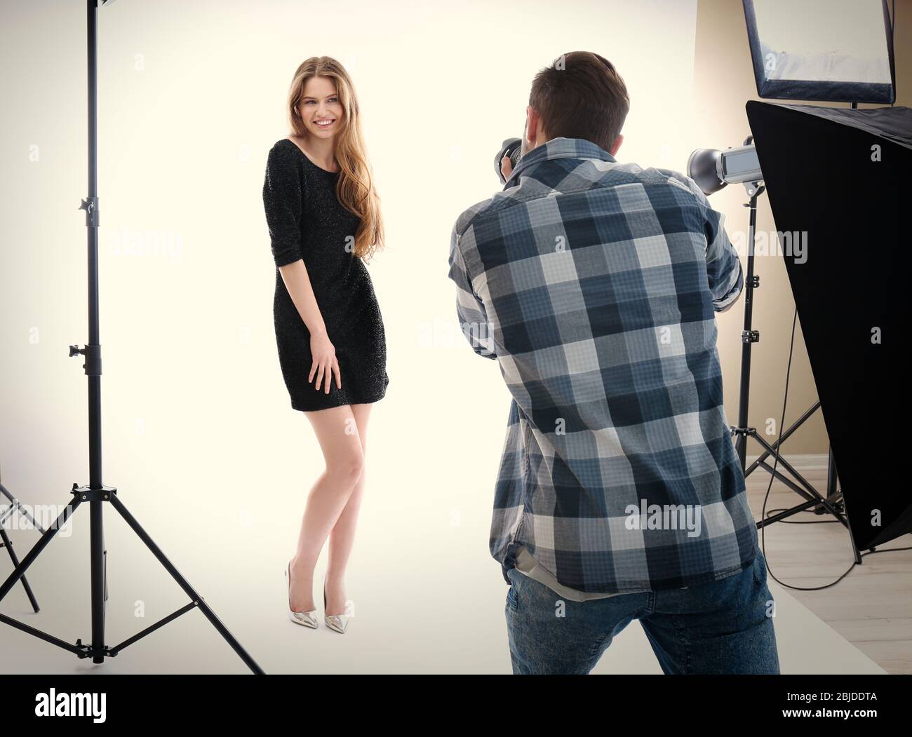 Photographer taking picture of model in studio Stock Photo - Alamy