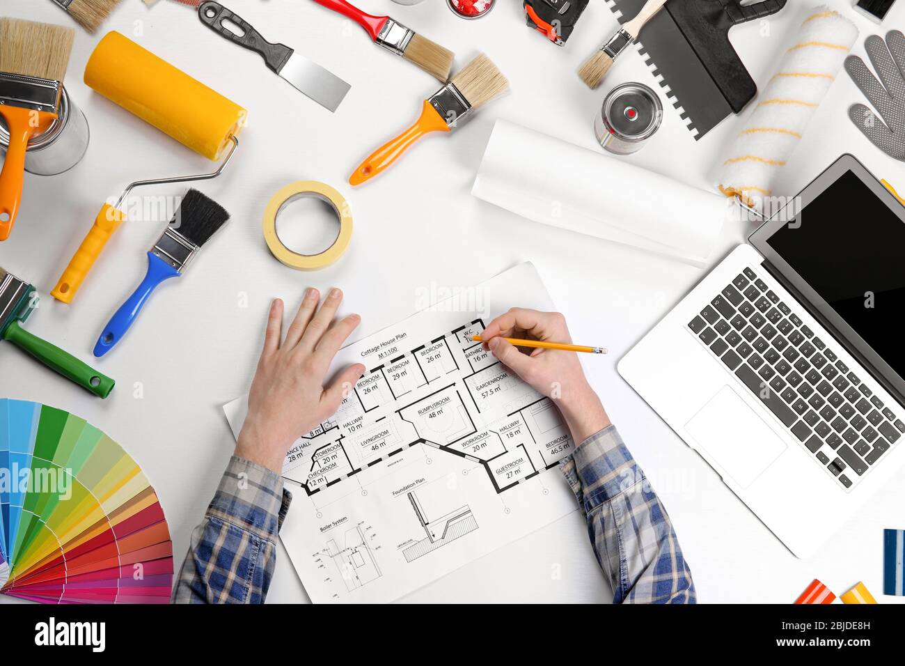 Decorator's hands with pencil on project drawing. Color swatches and ...