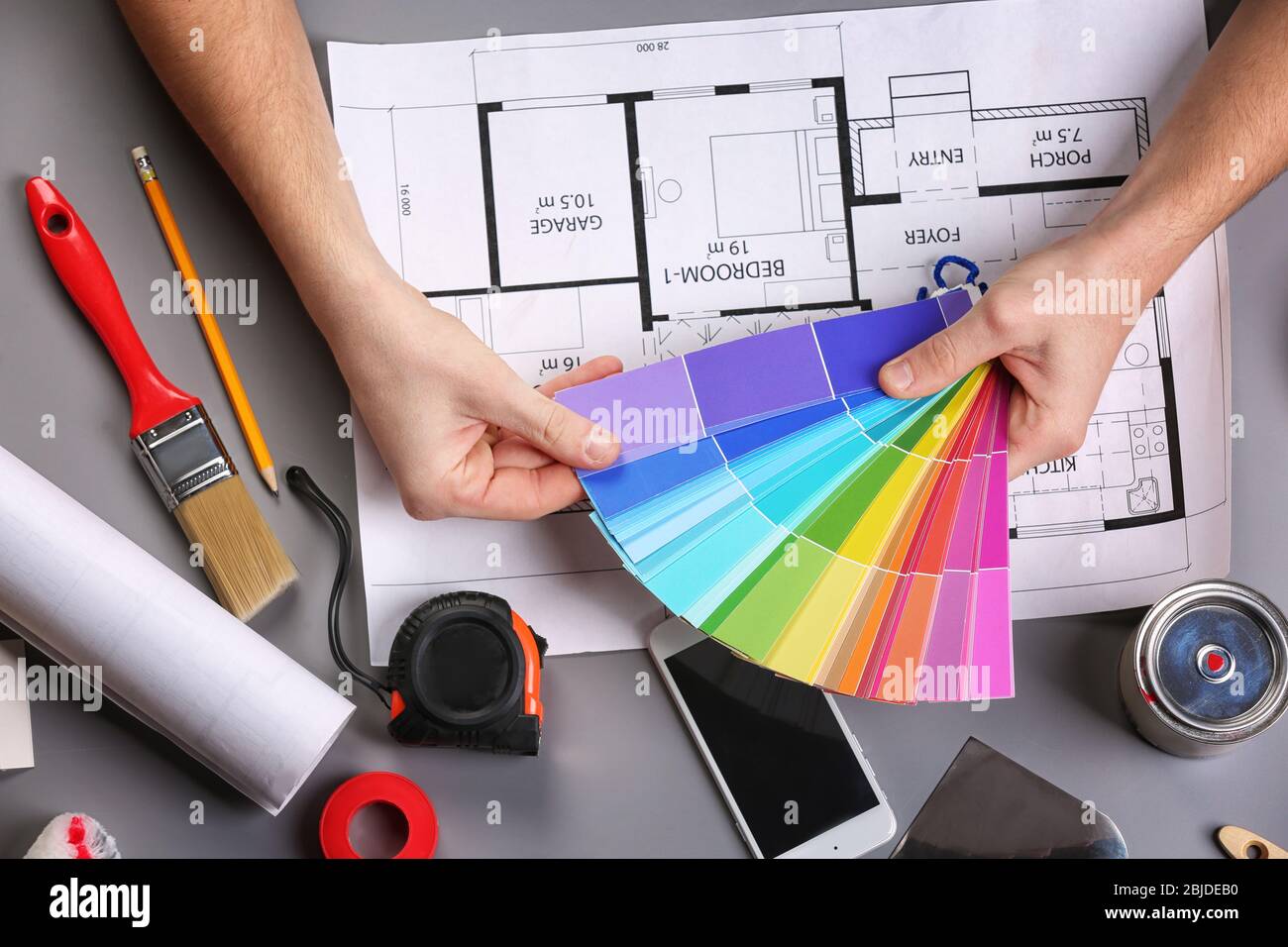Decorator's hands holding color swatches. Project drawing and paint ...