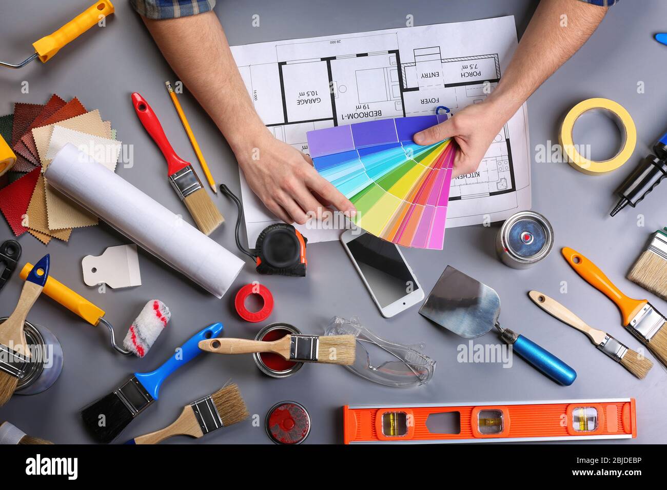 Decorator's hands holding color swatches. Project drawing and paint ...