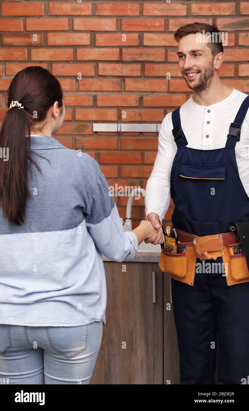 Plumber and woman shaking hands Stock Photo - Alamy