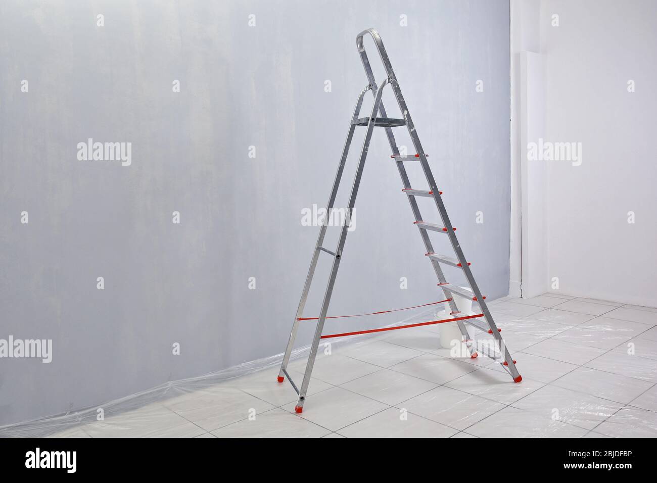 Ladder standing in empty room Stock Photo - Alamy