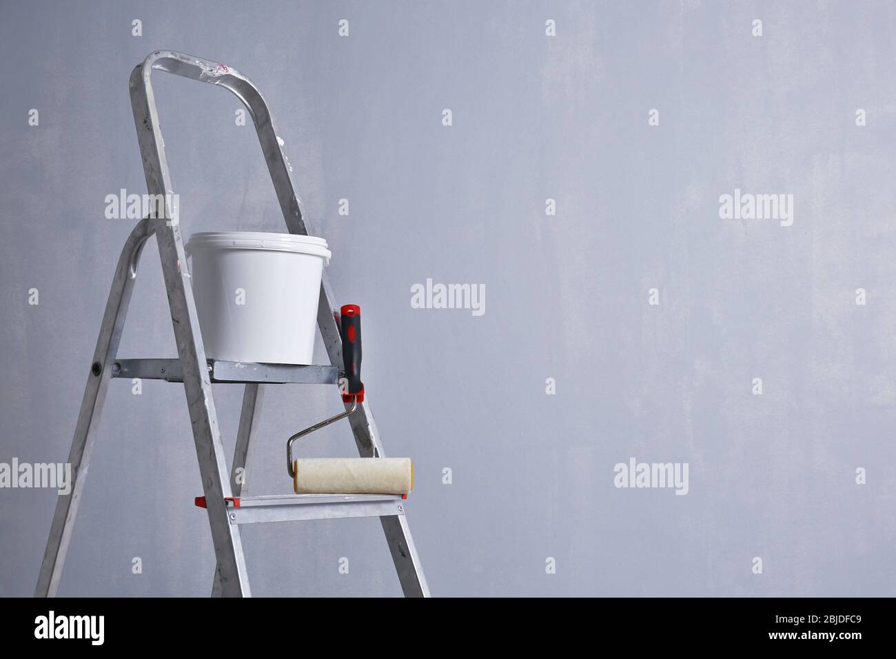 Ladder with paint and roller standing in empty room Stock Photo - Alamy