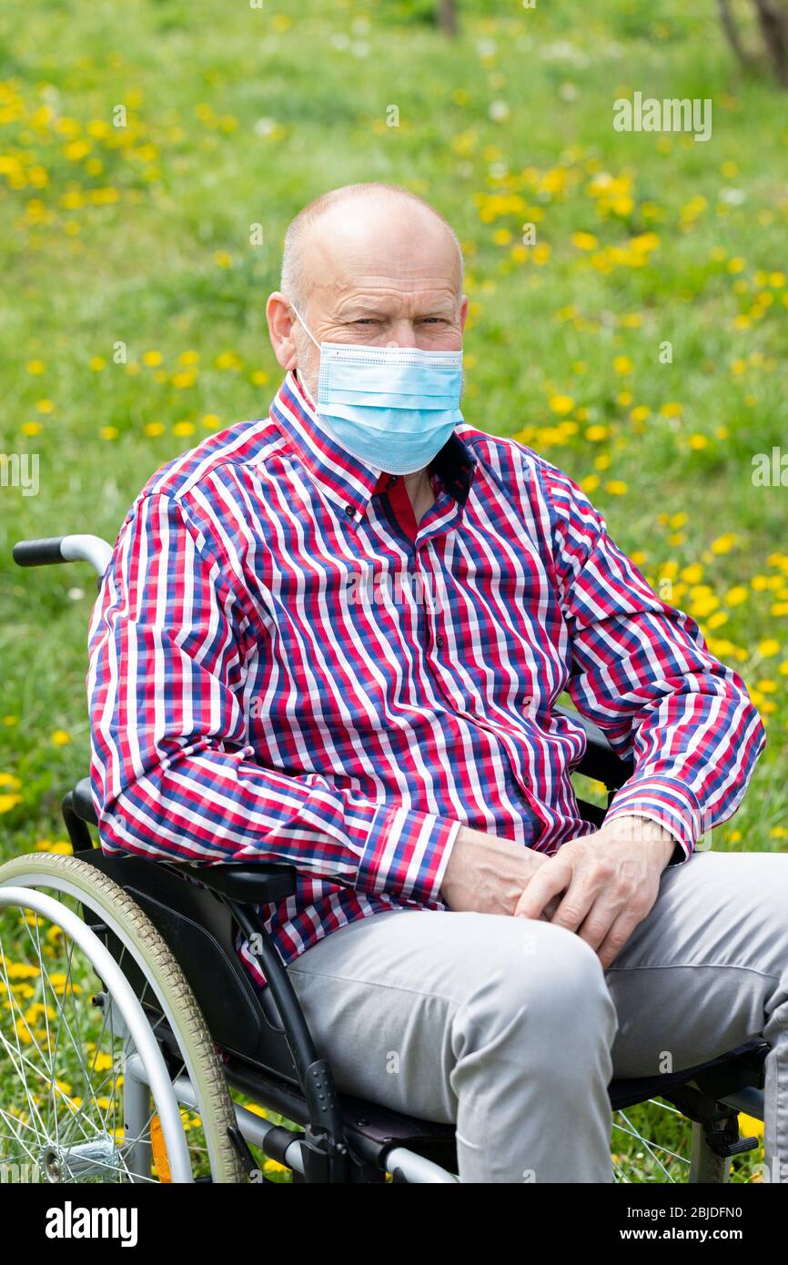 Elderly man with surgical mask sitting in a wheel chair outdoor - risk ...