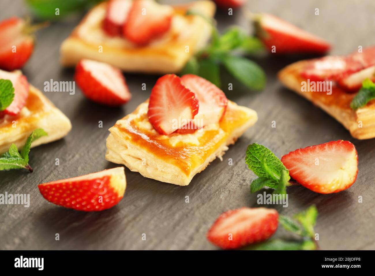 Sweet tasty pastries with fresh strawberries on textured background ...