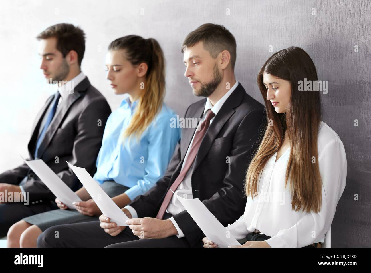 Group of young people waiting for interview indoors Stock Photo - Alamy