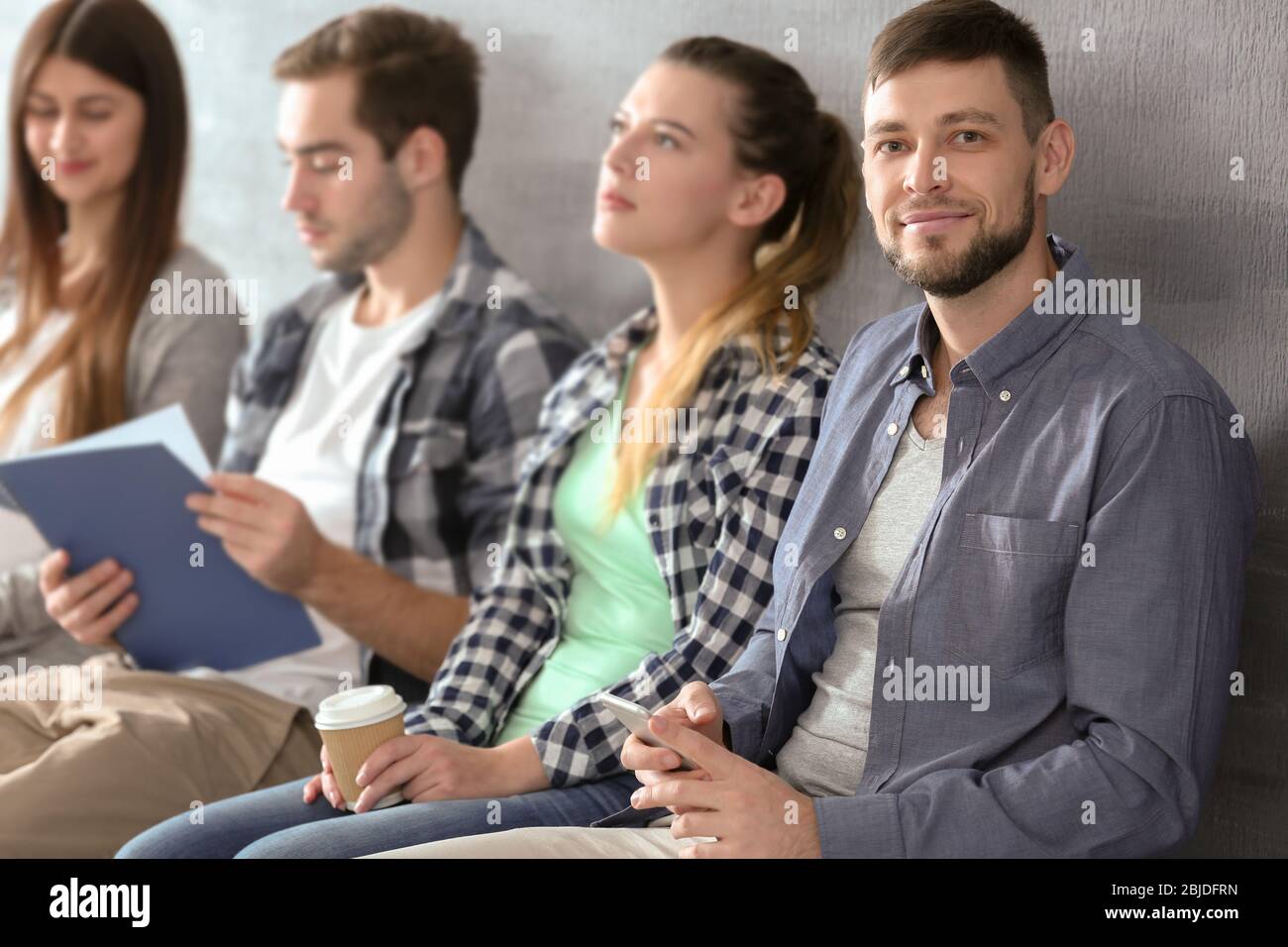 Group of young people waiting for interview indoors Stock Photo - Alamy