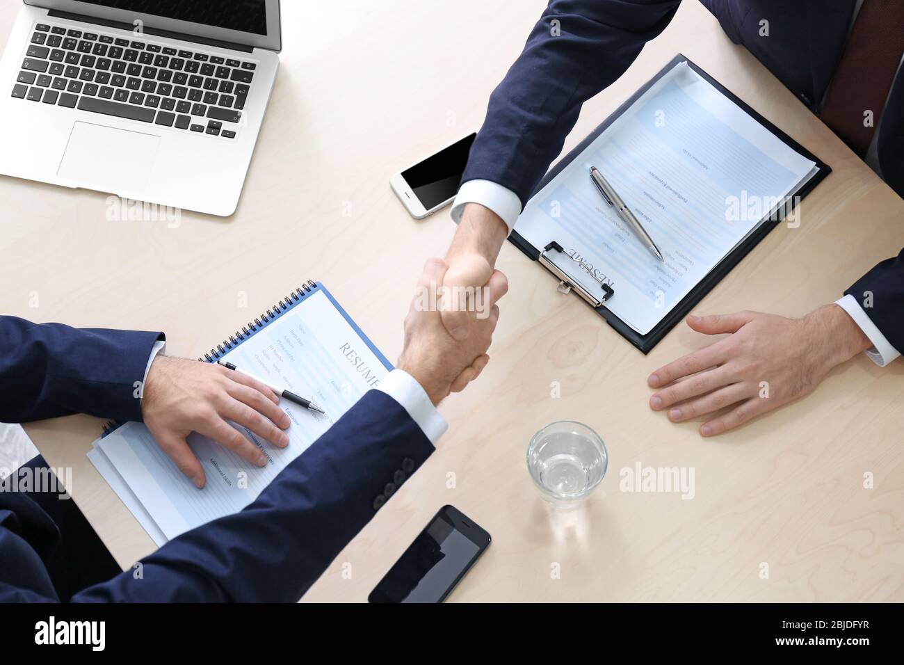 Employer and applicant shaking hands after interview Stock Photo - Alamy