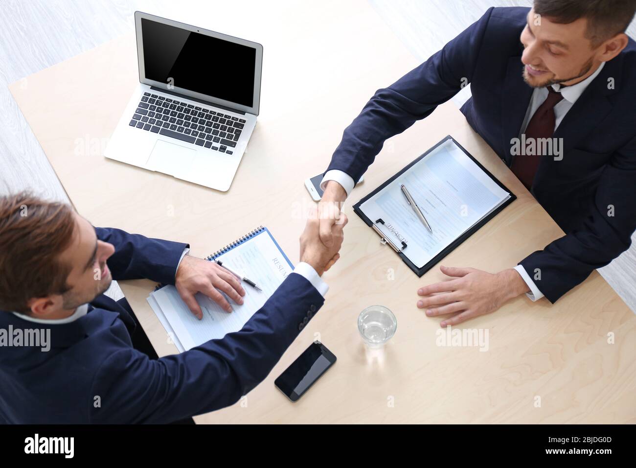 Employer and applicant shaking hands after interview Stock Photo - Alamy