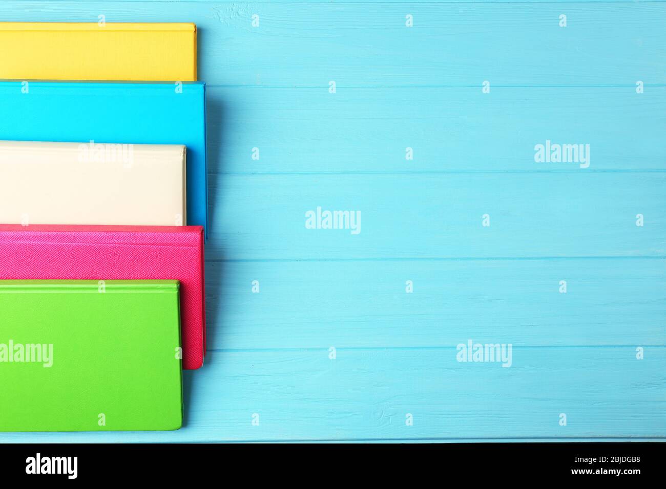 Colorful notebooks on wooden background Stock Photo - Alamy