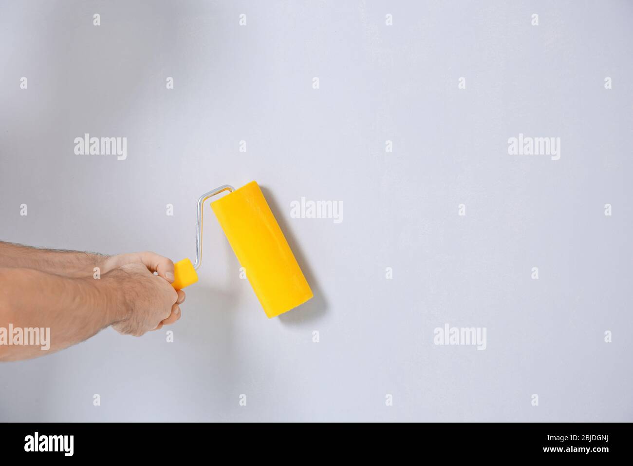 Hands of worker painting wall in room Stock Photo - Alamy