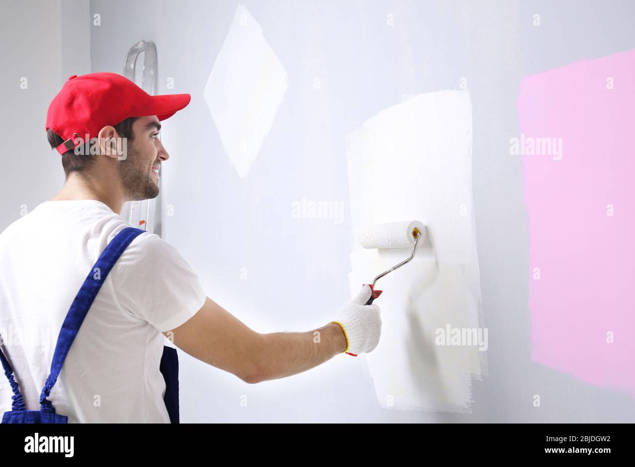 Young worker painting wall hi-res stock photography and images - Alamy