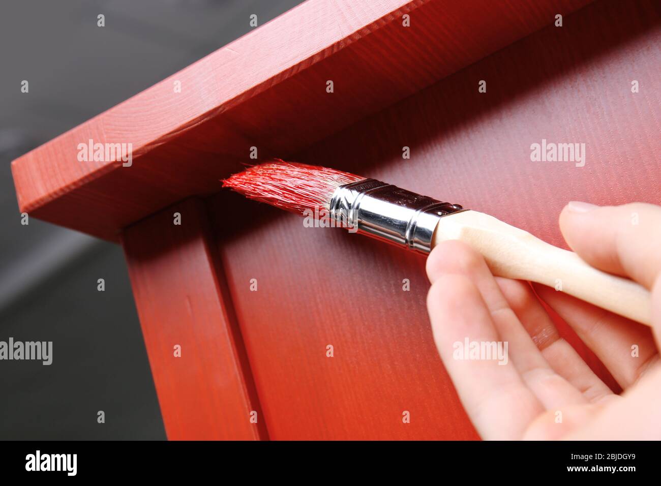 Close up view of human hand painting furniture Stock Photo - Alamy