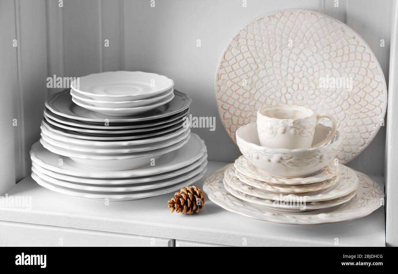 Different clean dishes in cupboard in the kitchen Stock Photo - Alamy