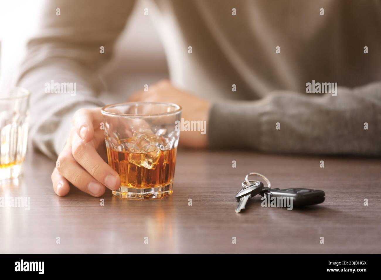Drunk man with car key and alcoholic beverage in bar, closeup. Don't ...