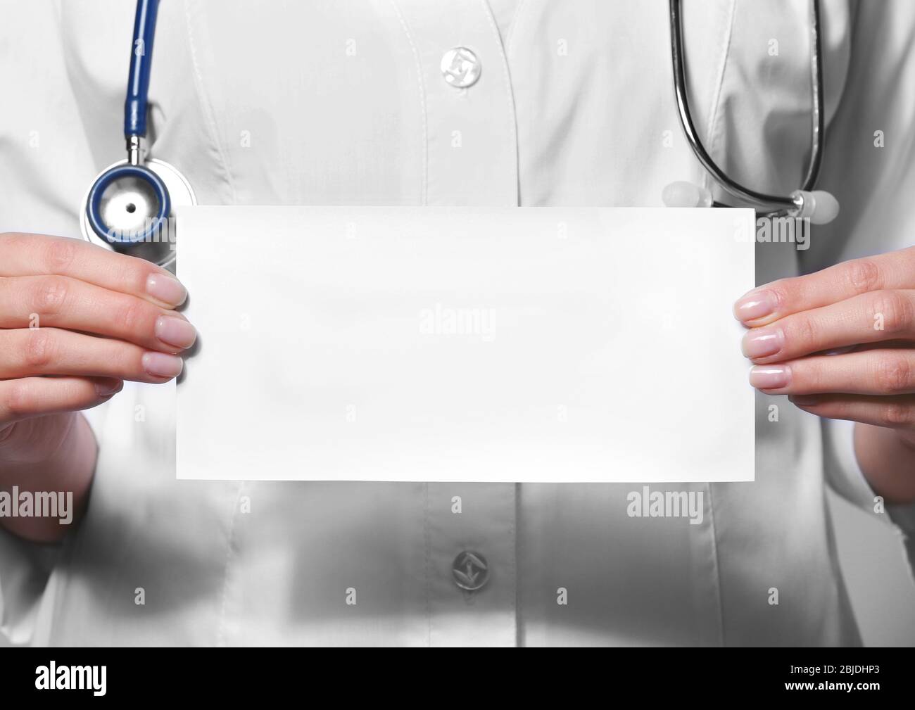 Close up view of doctor holding blank paper sheet Stock Photo - Alamy