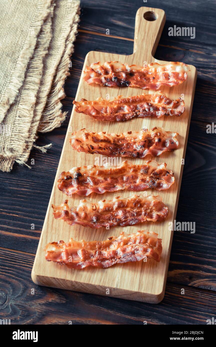 Fried bacon strips on the wooden board Stock Photo - Alamy