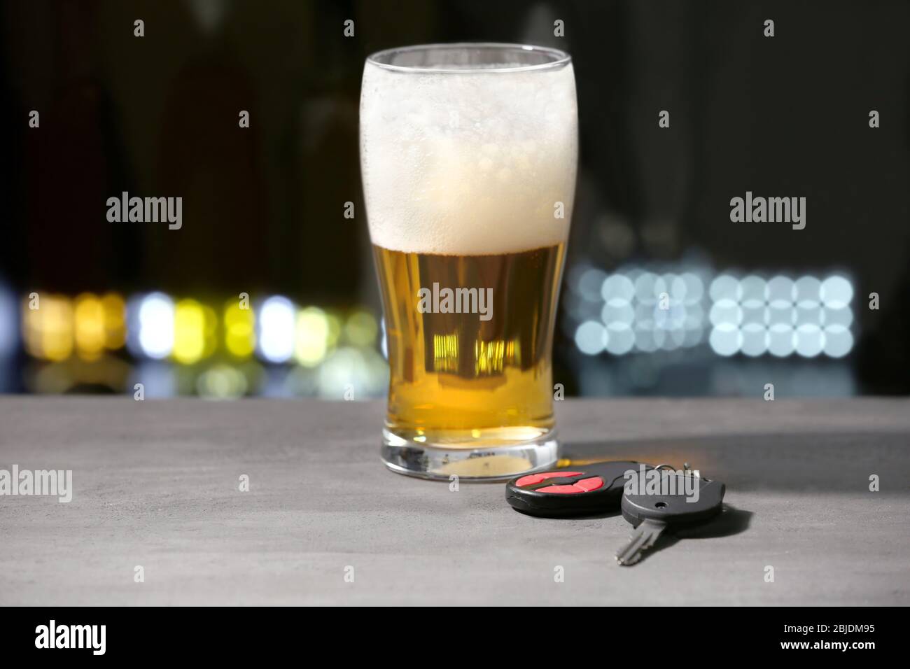 Glass of beer and car keys on grey table Stock Photo - Alamy