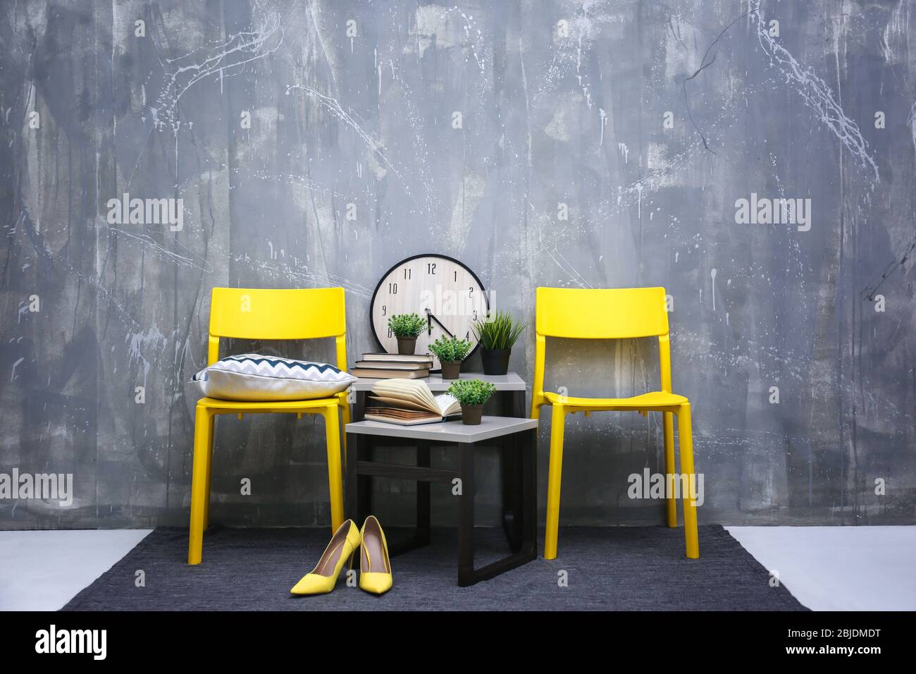 Modern interior design with yellow chairs and little table on grey ...