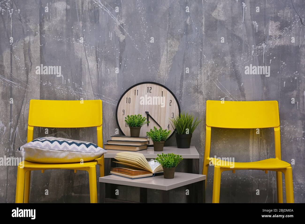 Modern interior design with yellow chairs and little table on grey ...