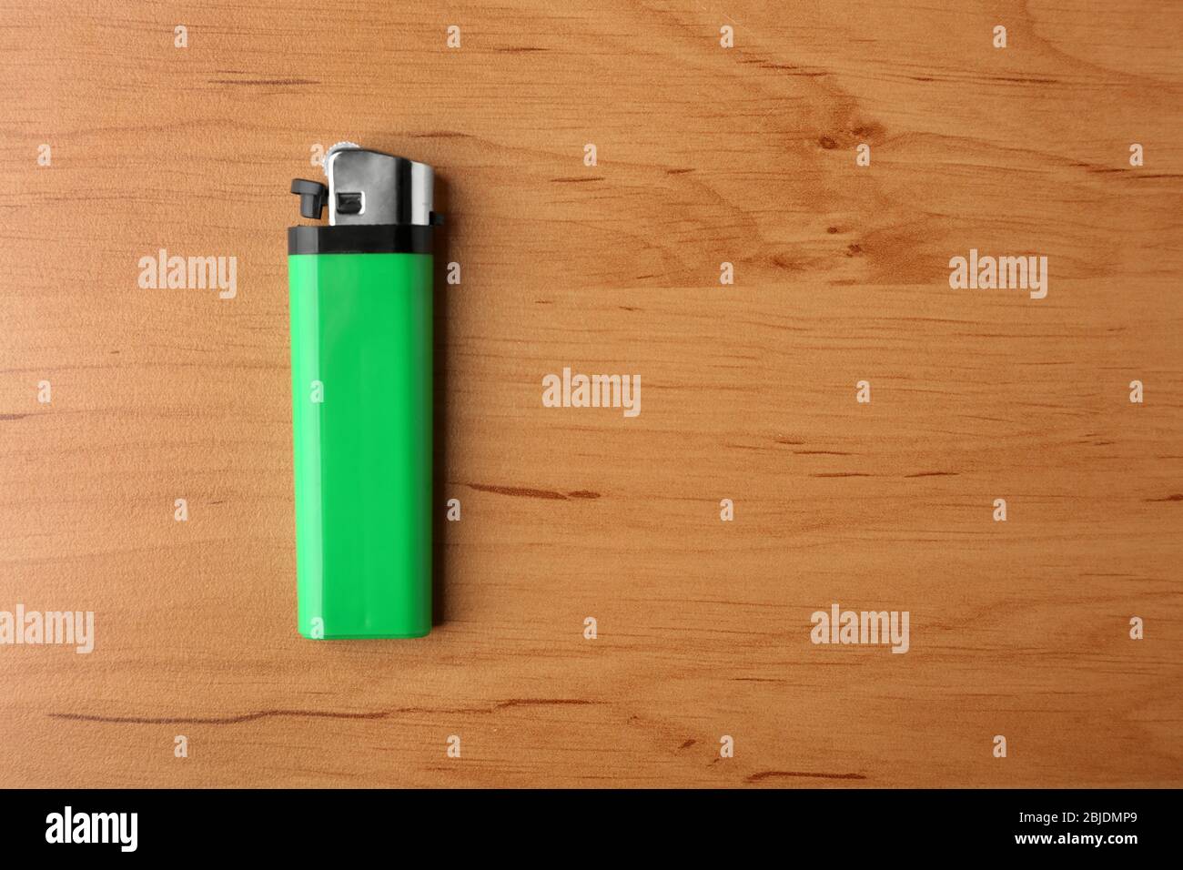 Green gas lighter on wooden background Stock Photo - Alamy
