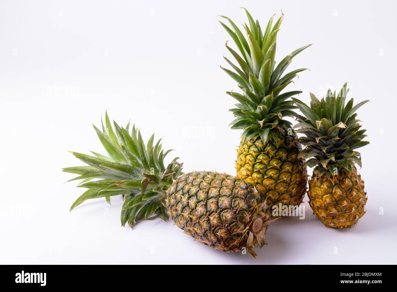 Ripe Pineapples Of Different Sizes Against White Background Stock Photo ...