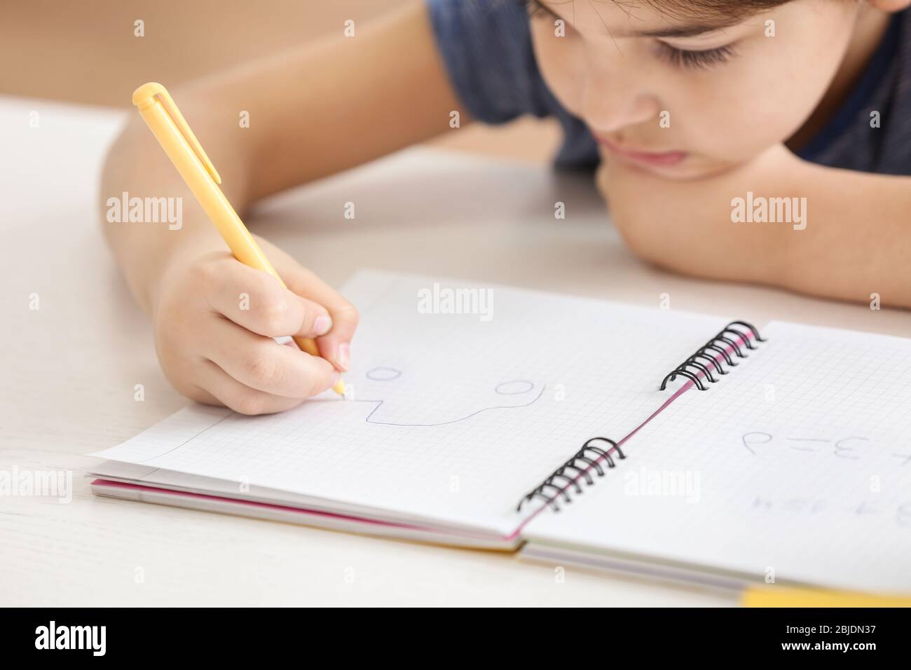 Cute little boy drawing something in notebook Stock Photo - Alamy
