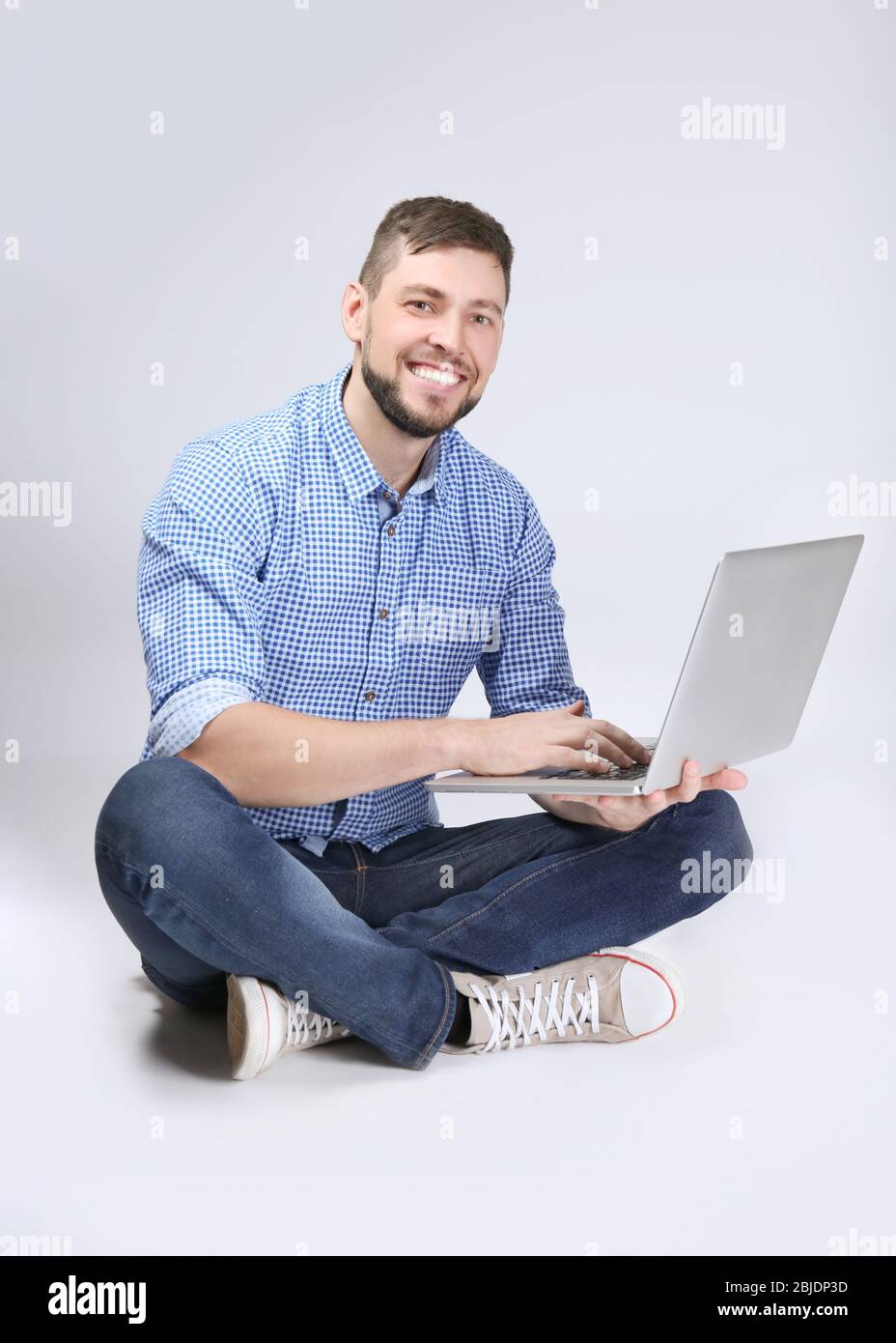 Handsome young programmer with laptop on color background Stock Photo ...