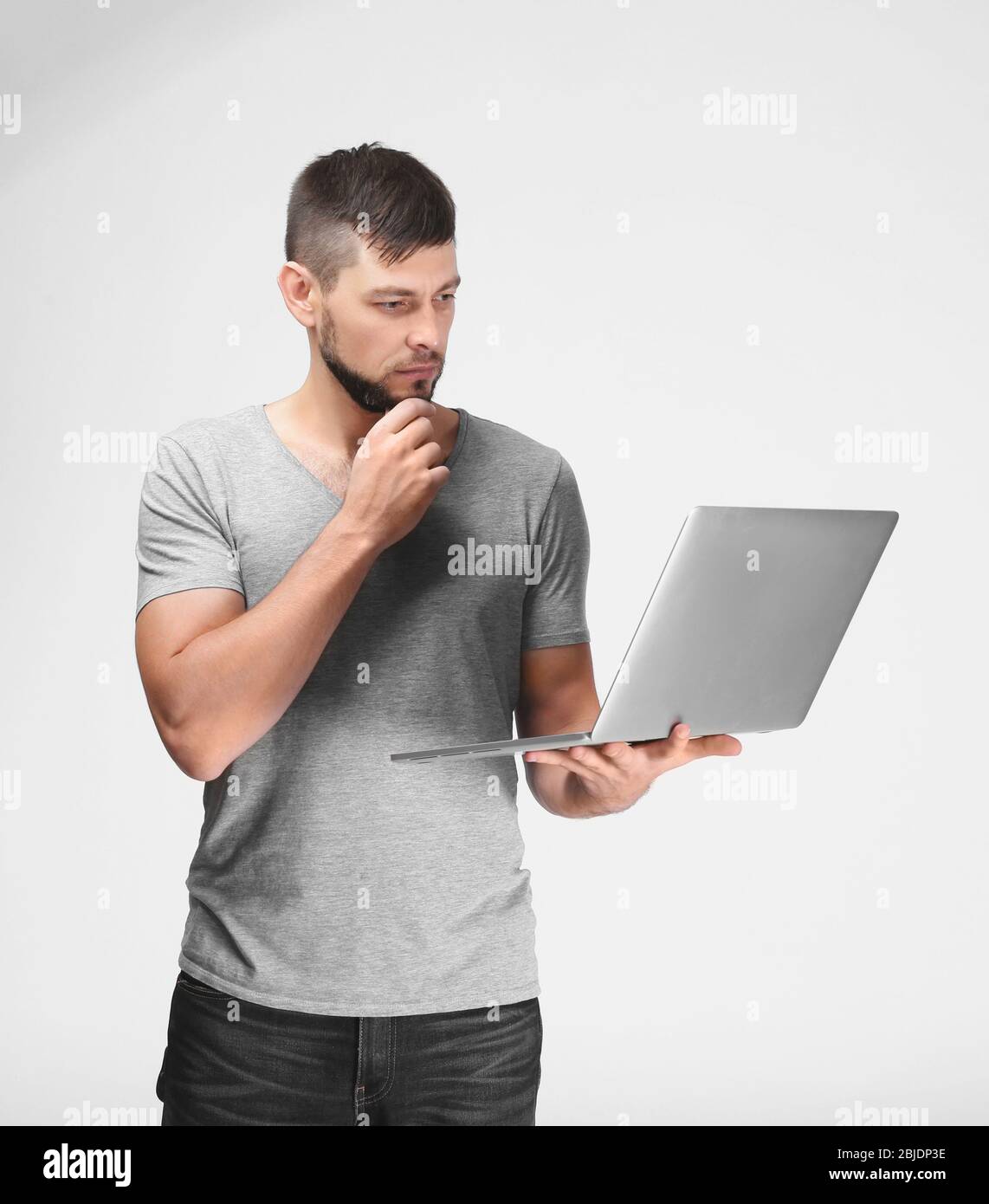 Handsome young programmer with laptop on color background Stock Photo ...