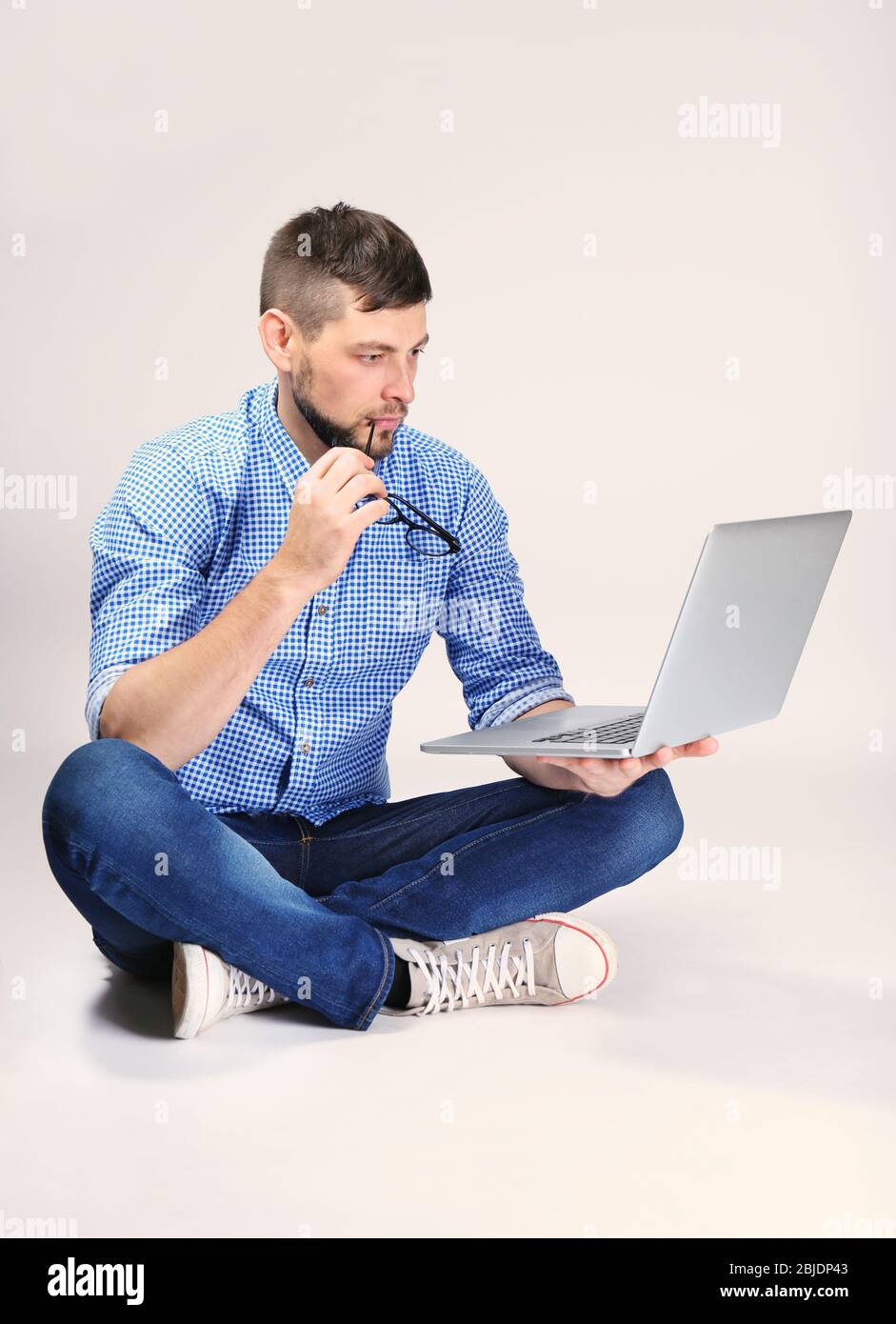 Handsome young programmer with laptop on color background Stock Photo ...
