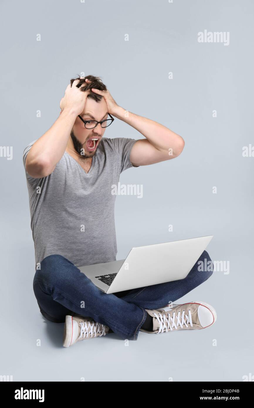 Handsome young programmer with laptop on color background Stock Photo ...