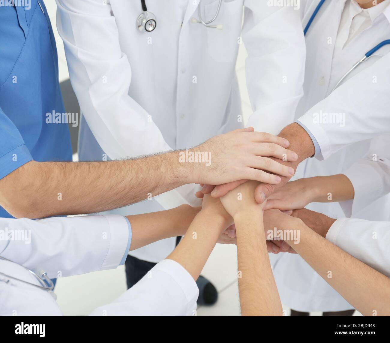 Team of doctors putting hands together, closeup Stock Photo - Alamy