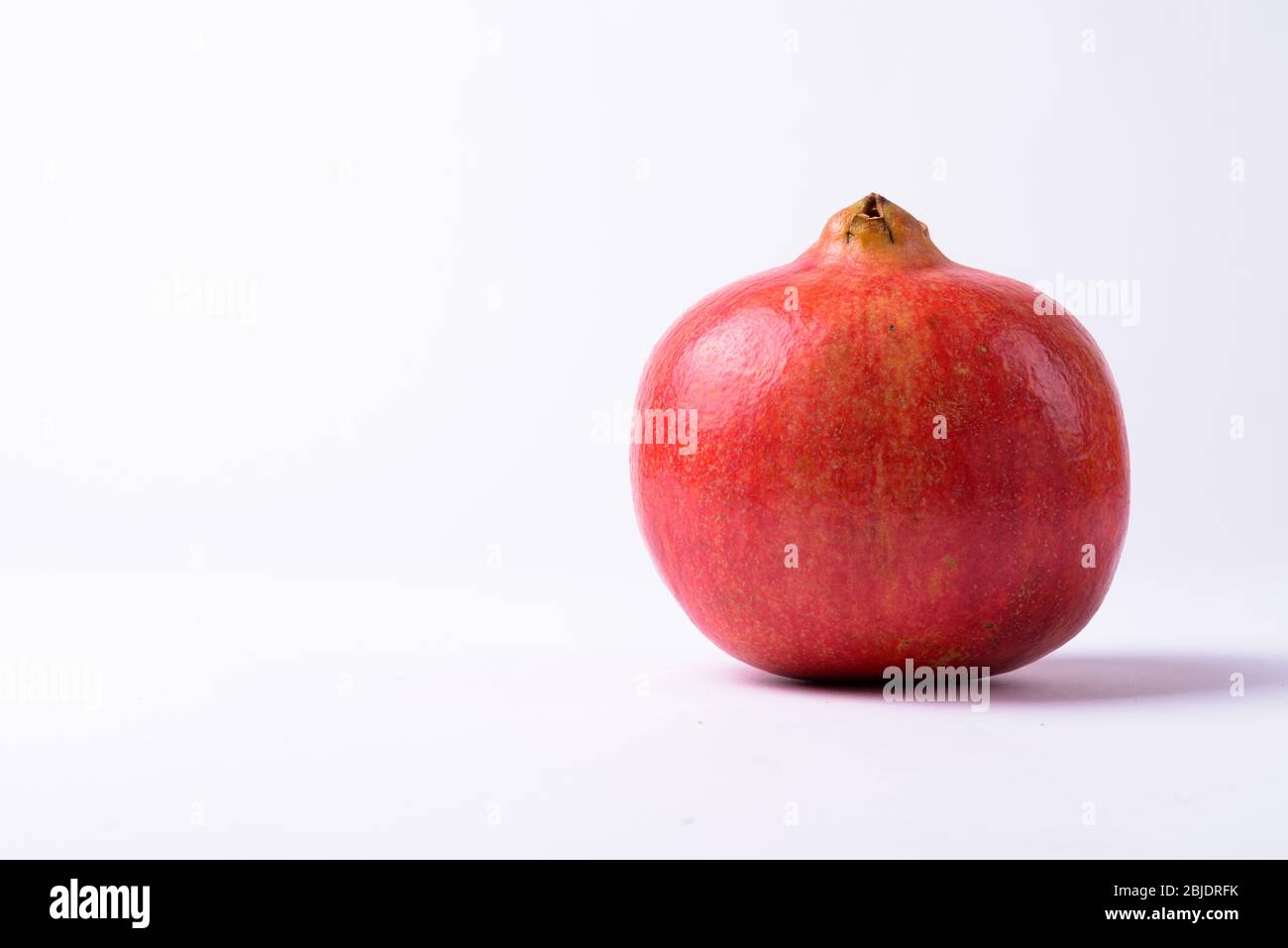 Portrait Of Single Pomegranate Against White Background Stock Photo - Alamy